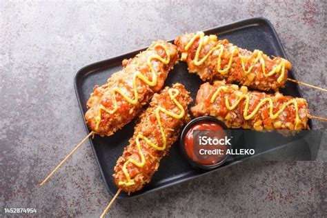 한국 옥수수 개는 핫도그 치즈 막대기에 반죽에 튀긴 감자 튀김으로 설탕 케첩 겨자 근접 촬영을 접시에 씌운 것입니다 수평 평면도 콘 도그에 대한 스톡 사진 및 기타 이미지