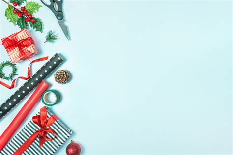 파란색 배경에 포장 재가 있는 검은색과 흰색 줄무늬 점선 및 빨간색 종이로 감싼 선물 상자 크리스마스는 준비를 제공합니다 빈 공간입니다 가위에 대한 스톡 사진 및 기타