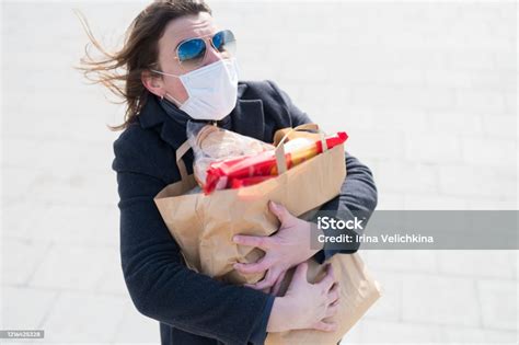 보호 얼굴 마스크에 무서워 여자회색 코트 화장지 파스타 쿠키 격리하기 전에 공예 가방에 음식의 저장을 만들기 제품의 부족 코로나