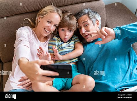 Mother And Son Taking A Selfie On Couch At Home Hi Res Stock