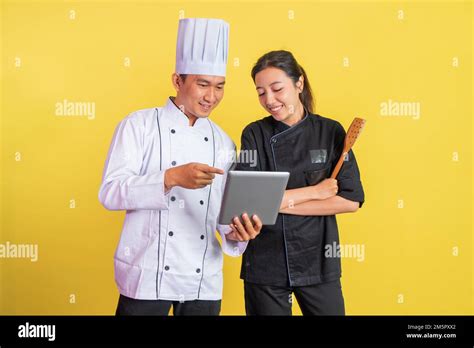 Male And Female Chefs Wearing Chef Jackets Using A Pad Stock Photo Alamy