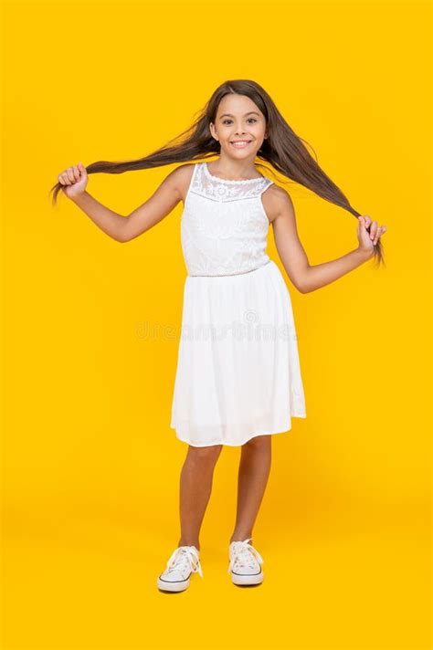 Cute Teen Girl In White Dress Standing On Yellow Background Stock Image