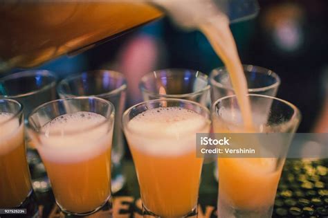 밤에 야외 이벤트에 장식 된 케이터링 꽃다발 웨딩 테이블에 야외 파티 마티니 보드카와 거품 및 다른 사람에 민트와 다른 색깔된 알코올 칵테일의 아름 다운 행 선 과일에 대한