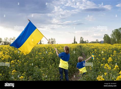 Mother And Son In Yellow Blue T Shirts With Flag Of Ukraine In Hands