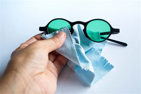 여자의 왼손 청소 검은 색 선글라스 극세사 청소 천 흰색 배경에 클로즈업 및 매크로 샷 선택적 초점 광학 개념 개인 장식품에 대한 스톡 사진 및 기타 이미지 Istock