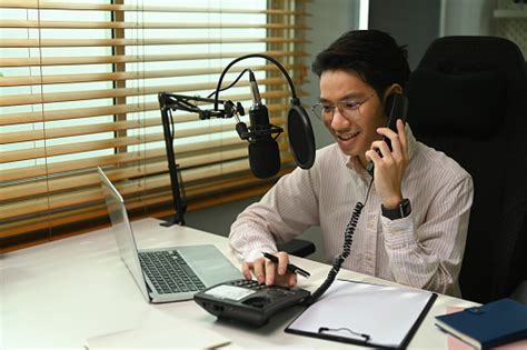 홈 스튜디오에서 채널을위한 오디오를 녹음하는 마이크와 노트북 컴퓨터를 사용하는 젊은 팟 캐스트 작성자 20 24세에 대한 스톡