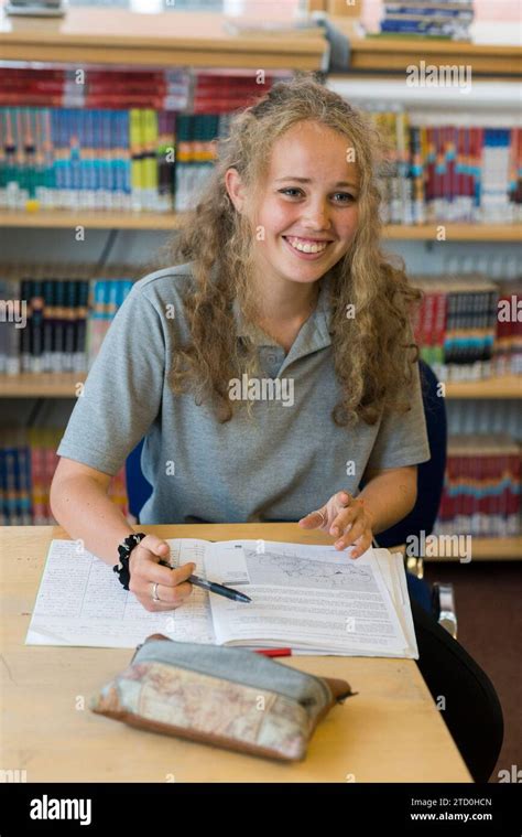 A Female A Level Babe Sits At A Desk In A Babe Library Revising Stock Photo Alamy
