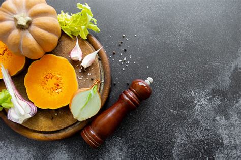 신선한 밝은 야채가 나무 커팅 보드에 배치됩니다 버터넛 스쿼시 녹색 셀러리 잎 검은 고르지 않은 배경 복사 공간 Cooking