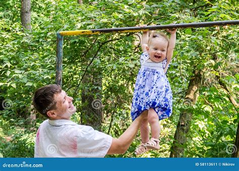 Paizinho E Filha Que Jogam No Parque Em Um Fundo Das árvores No Bebê