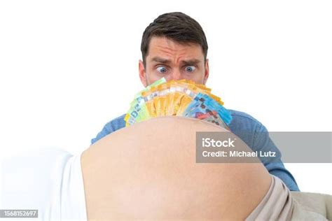 임산부는 임신한 아기 범프 앞에서 얼굴 앞에 있는 지폐 더미를 믿을 수 없다는 듯이 곁눈질합니다 임신 마지막 달 39 주 흰색 배경입니다 밝은 샷 2명에 대한 스톡 사진 및