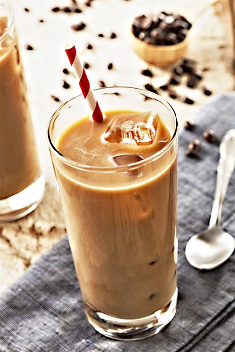 two glasses filled with liquid sitting on top of a blue cloth next to ...