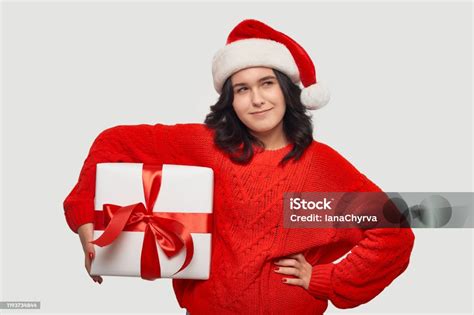 빨간 스웨터와 산타 클로스 모자에 갈색 머리 소녀는 빨간색 리본흰색 선물 상자를 들고 12월에 대한 스톡 사진 및 기타 이미지 12월 갈색 머리 겨울 Istock