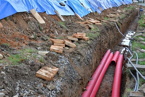 지상에 고전압 케이블을 배치 환경은 전신주를 손상시키지 않습니다 땅 깊은 발굴 미터 검은 색 플라스틱 코팅 강한 케이블 와이어 감전의 위험 가리기에 대한 스톡 사진 및 기타