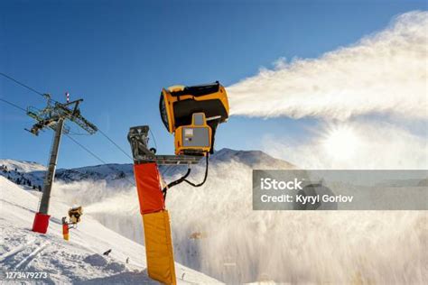 눈가루를 만드는 피스트 근처에서 인공 눈 대포를 작동합니다 화창한 날에 힐랜드 알프스 산 겨울 리조트의 스키 리프트 로프웨이