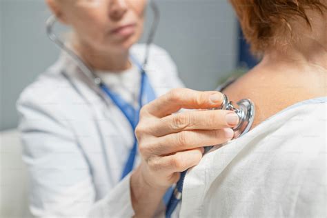Close Up Of Doctor Examining Senior Patient With Stethoscope At