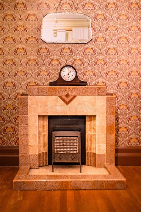 Vintage Fireplace With Classic Clock And Ornate Wallpaper Stock