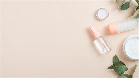 파스텔 베이지 색 배경에 손 관리 및 녹색 허브 잎에 대한 에센셜 오일 화장품 병 투명 용기 자연 미용 제품 컨셉 최소한의 플랫 레이 스타일 구성 공중 뷰에 대한 스톡 사진