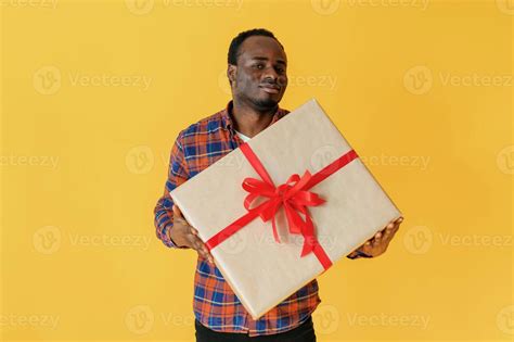 With Big Present T Box Black Man Is In The Studio Against Yellow