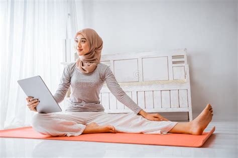 muslim hijab woman watching home work out tutorial from tablet stock