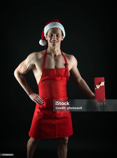 크리스마스 조리법 크리스마스 정신 크리스마스 전통 즐거운 성탄절 근육질의 남자는 산타 클로스 모자를 착용 검은 색 배경에 보디 빌더 겨울 방학 근육 스포츠맨은 새해를 축하