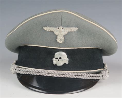 A Ww2 German Waffen Ss Officers Peaked Cap With Metal National Emblem And Totenkopf Skull Insign