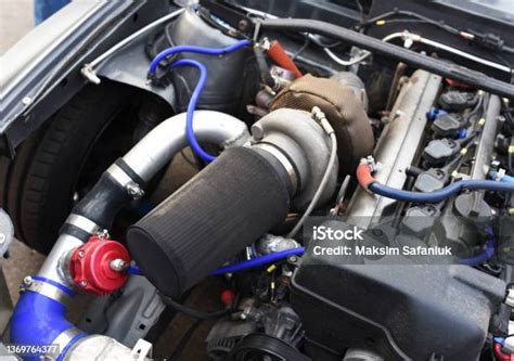 터빈이 있는 스포츠카 엔진 경주 트랙에서 경주하는 동안 피트 정지에 열린 경주 용 자동차 후드 터보 차저가 장착 된 모터 Brand Name Domestic Car에 대한