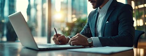 a man dressed in a formal suit is sitting at a table using his laptop