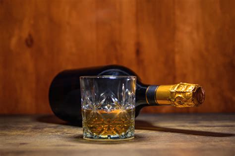 샴페인 한 병이 나무 테이블 위의 위스키 한 잔 옆에 놓여 있습니다 와인 저장고 장면 0명에 대한 스톡 사진 및 기타 이미지 0명 각얼음 갈색 Istock