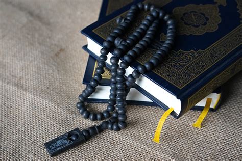 꾸란은 꾸란 또는 코란로도 로마자 표기되어 있으며 이슬람교도들이 하나님 의 계시라고 믿는 이슬람의 중심 종교 텍스트입니다 검은 기도 구슬 0명에 대한 스톡 사진 및 기타