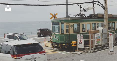 바다 옆의 선로를 따라 이동하는 녹색과 노란색 기차 사진 Unsplash의 무료 가나가와 현 이미지