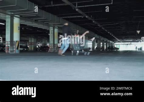 The Man Rolls The Woman In The Trolley From The Supermarket In The Underground Parking The Guy