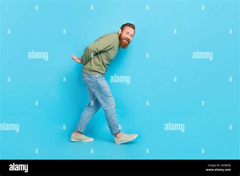 Full Size Photo Of Funny Upset Man With Red Hairstyle Dressed Khaki Pullover Hold Arms Behind