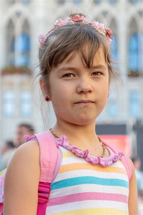 A Girl With A Serious Expression And A Backpack On Her Back Poses On