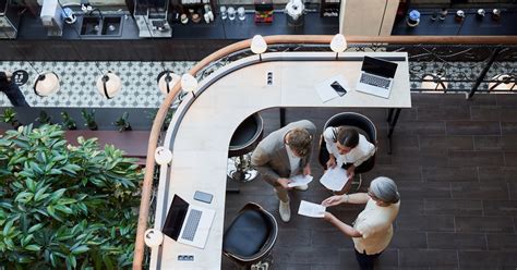 두 명의 부지런한 젊은 학생이 편안한 라운지에 앉아있는 동안 튜터의지도하에 프로젝트를 진행하고 있습니다 사진