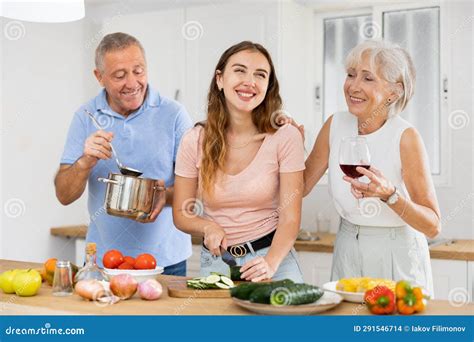 счастливая семья из трех человек готовит обед вместе на современной кухне Стоковое Фото