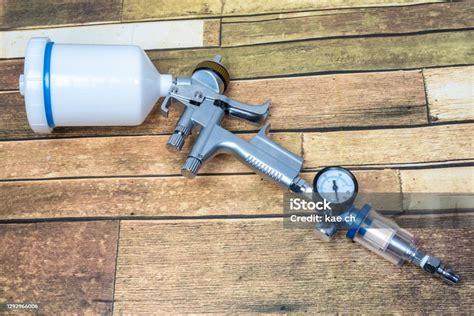 나무 바닥에 페인트 스프레이 산업 회화 및 코팅에 사용되는 산업 크기 스프레이 건을 들고 화가의 팔 손의 이미지 배경 클리핑 파트에 절연 0명에 대한 스톡 사진 및 기타