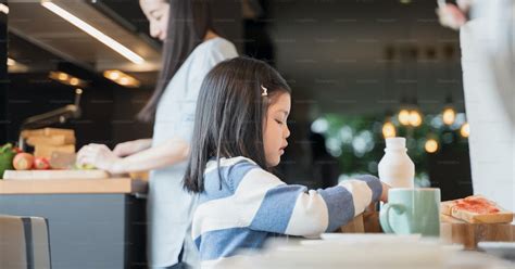 엄마와 딸은 부엌에서 아침 식사를 하는 우유와 함께 시리얼을 먹고 있다 사진 Unsplash의 작다 이미지