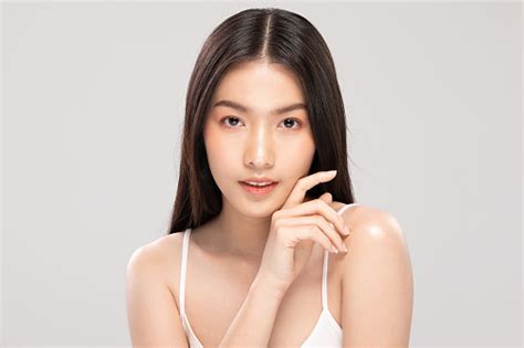 깨끗하고 신선한 피부 행복과 긍정적 인 감정과 명랑 흰색 배경 아름다움과 화장품 개념에 고립 된 부드러운 뺨 미소를 만지는 아름다운 아시아 여성 건강관리와 의술에 대한 스톡