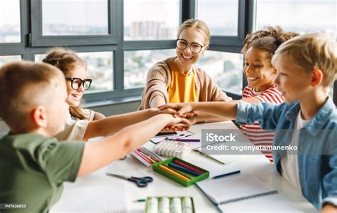 교사와 즐거운 학생들은 밝은 교실에서 집단 학교 일의 성공적인 완료를 축하합니다 사춘기 이전 어린이에 대한 스톡 사진 및 기타 이미지 사춘기 이전 어린이 단체 교육