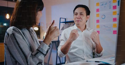 아시아 사업가와 사업가 그룹은 캐주얼 한 토론 사업에서 행복한 느낌을 받고 야간 사무실에서 계약 또는 계약에 서명 한 후 5 명을주는 것을 축하합니다 동료 팀워크 개념