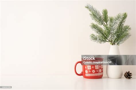 눈송이 디자인의 빨간 머그잔과 꽃병에 담긴 소나무 가지가 특징인 측면의 평화로운 겨울 장식입니다 아늑하고 축제 테마에 이상적 12월에 대한 스톡 사진 및 기타 이미지
