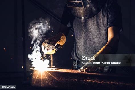 안전 장비를 착용하는 동안 공장에서 강철을 용접하는 아크 용접 기와 함께 작동하는 금속 용접기 수동 기술 노동 개념에 의해 금속 가공 제조 및 건설 유지 보수 서비스 강철에