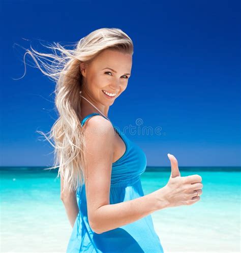 Ragazza Bionda Felice Sulla Spiaggia Mostrante I Thungs Su Fotografia