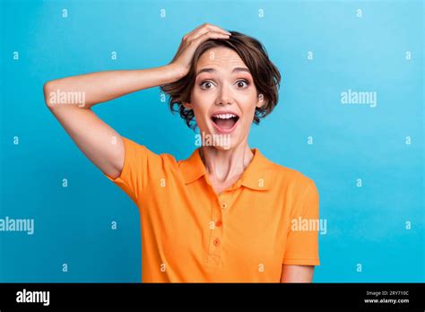 Photo Of Girly Shocked Girl Dressed Orange Polo Arm Head Open Mouth Isolated Blue Color