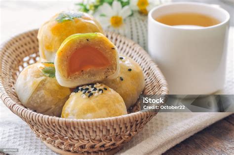 맛 있는 중국 생 과자 또는 달 케이크 녹두 반죽으로 가득 하 고 소금에 절인 계란 노 른 자 쪽 보기에서 나무 테이블에 차를 곁들여 나무 바구니에 복사 공간을 닫습니다 수