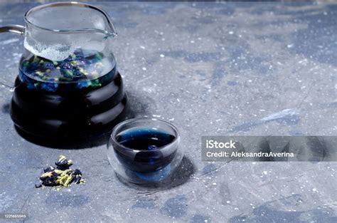 회색 파란색 콘크리트 배경에 블루 티와 이중 바닥유리 컵과 유리 주전자 클리토리아 차의 말린 꽃 따뜻하고 아늑한 분위기 공간