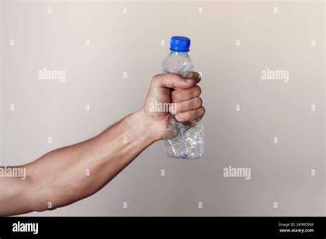Hand Squeezing Plastic Bottle Representing Movement Against Pollution