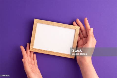 흰색 종이가 있는 나무 프레임을 모형으로 생생한 보라색 배경에 인간의 손이 있습니다 할로윈 휴일은 텍스트 템플릿 평면 누워에