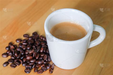 咖啡杯和豆子放在木桌上