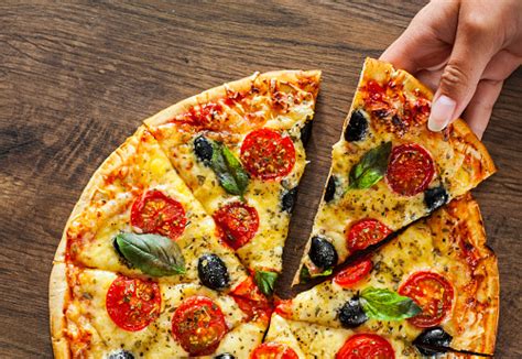 여자 손 모 짜 렐 라 치즈 토마토 올리브 피자 마르게리타 또는 마가리타의 슬라이스를 걸립니다 이탈리아 피자 나무 배경 건강에